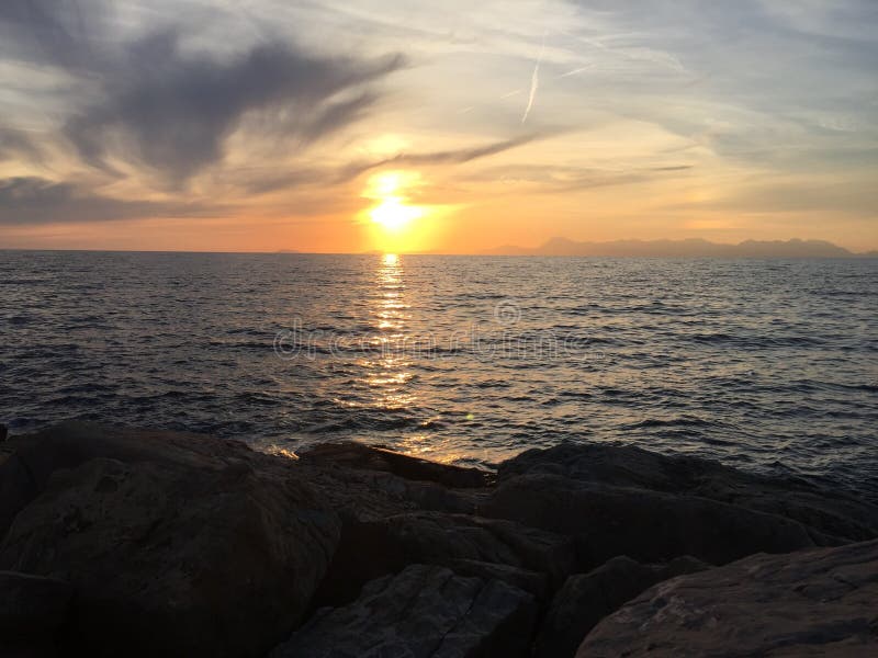 A Sunset from Italian Beach with the Dark Sea and Some Clouds Stock ...