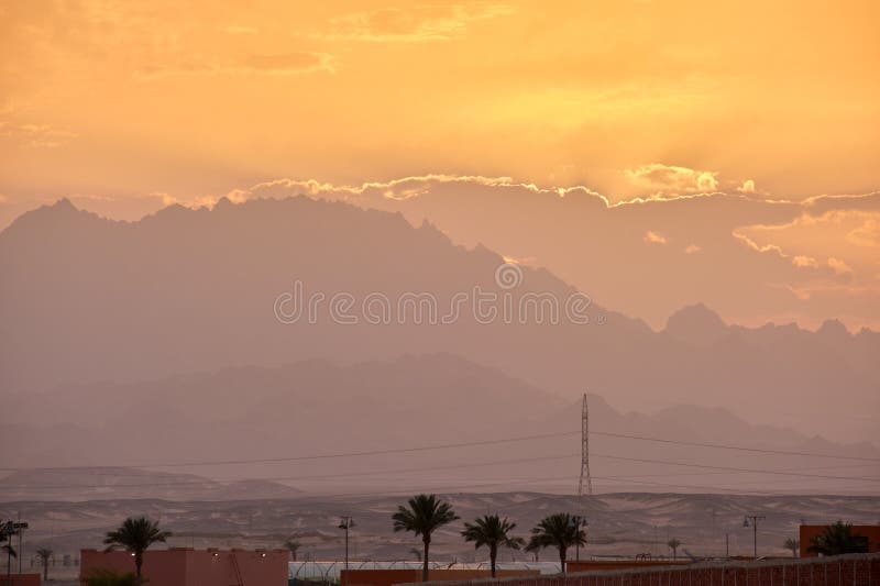 Sunset Landscape with Remote Hotel Complex Against Dark Mountain Peaks ...