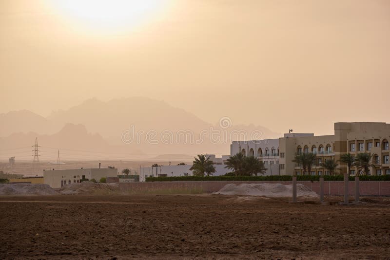Sunset Landscape with Remote Hotel Complex Against Dark Mountain Peaks ...