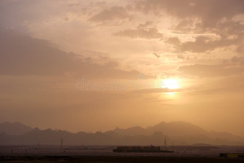 Sunset Landscape with Remote Hotel Complex Against Dark Mountain Peaks ...