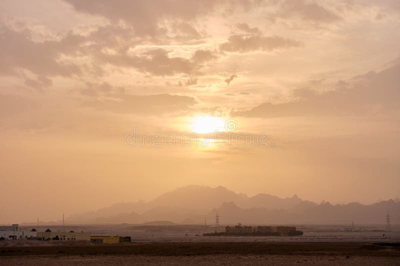 Sunset Landscape with Remote Hotel Complex Against Dark Mountain Peaks ...