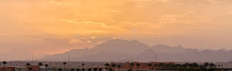 Sunset Landscape with Remote Hotel Complex Against Dark Mountain Peaks ...