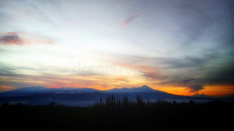 Sunset with Mountains Covering it Stock Photo - Image of horizon, color ...