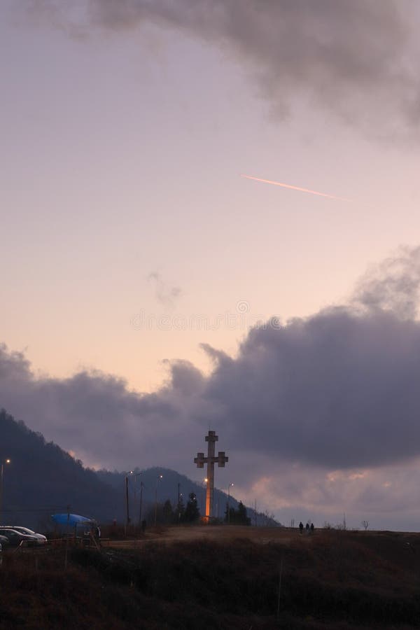Sunset in the Mountains with a Cross in the Foreground and Clouds in ...