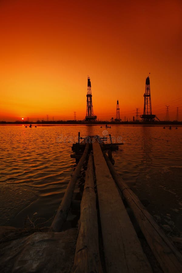 Sunset of Oil Drilling Rig in the Sea Stock Image - Image of electric ...