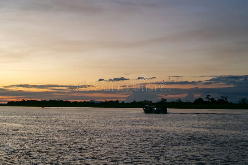 Sunset Over the Amazon River with a Riverboat in the Foreground and ...