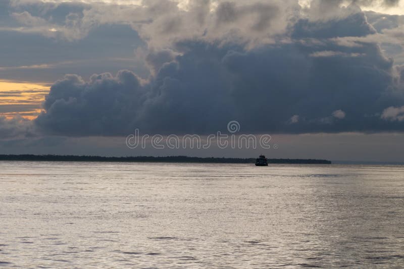 Sunset Over the Amazon River with a Riverboat in the Foreground and ...