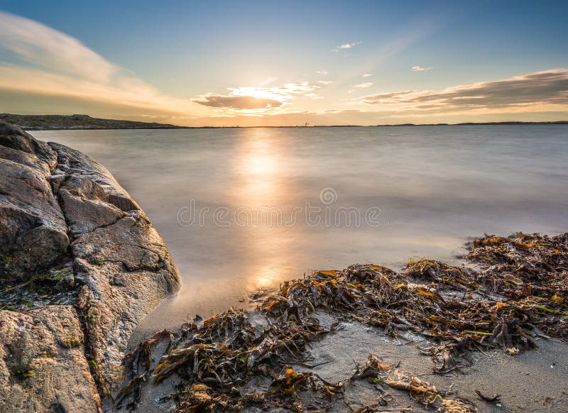 Sunset Over a Beach by a Cliff Stock Image - Image of sunlight ...