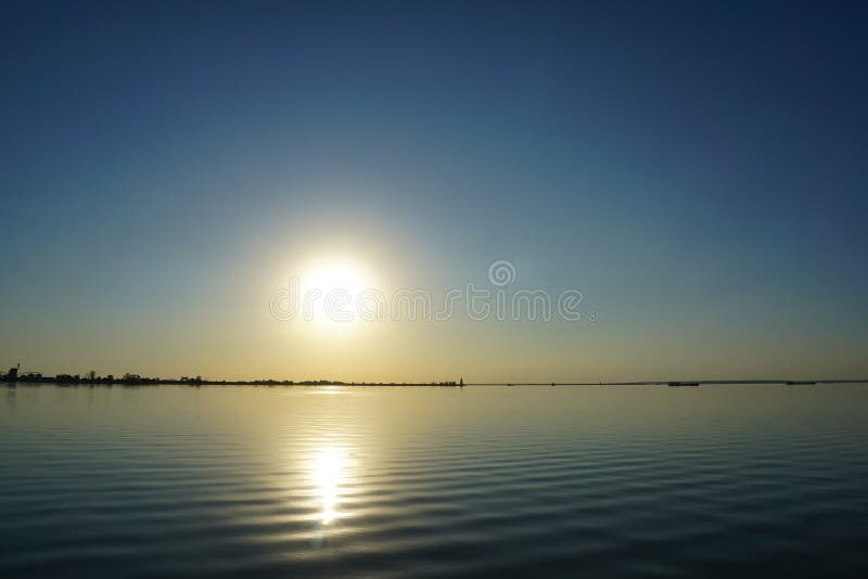 Sunset Over the Calm Surface of the Lake and Beautiful Glare of the Sun ...