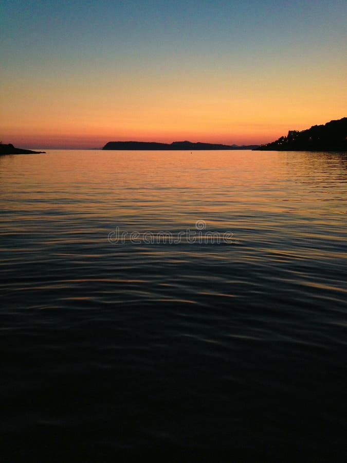 Sunset over calm waters stock image. Image of land, setting - 38170247