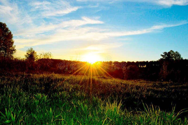 A Sunset Over a Grass Field Stock Photo - Image of lighting, cloud ...