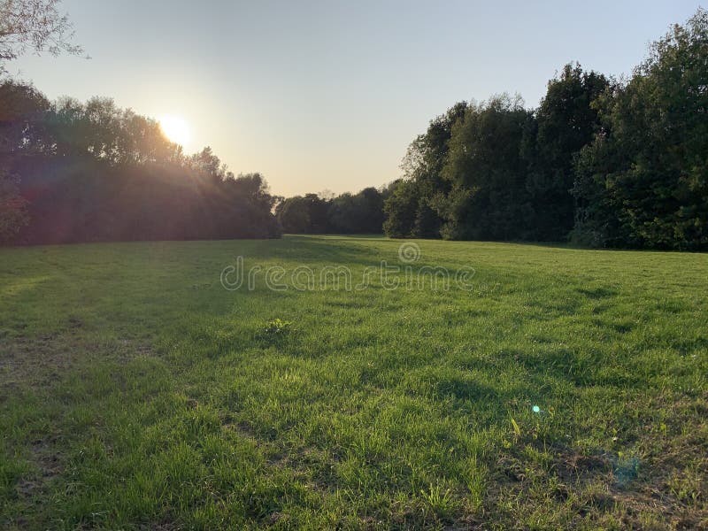 Sunset Over a Meadow Field Landscape Stock Photo - Image of clouds ...