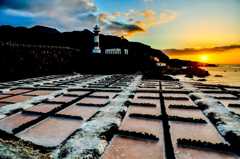A Sunset Over the Ocean with a Lighthouse in the Background Stock Photo ...