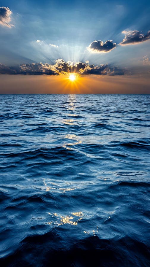 A Sunset Over the Ocean with the Sun Setting in the Distance Stock ...