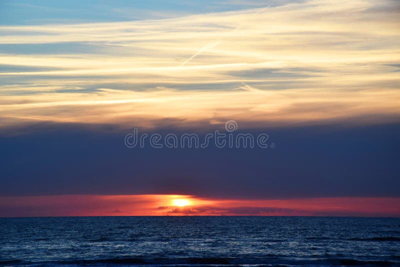Sunset Over the Ocean - View of the Red Sun Sinking into the Horizon ...