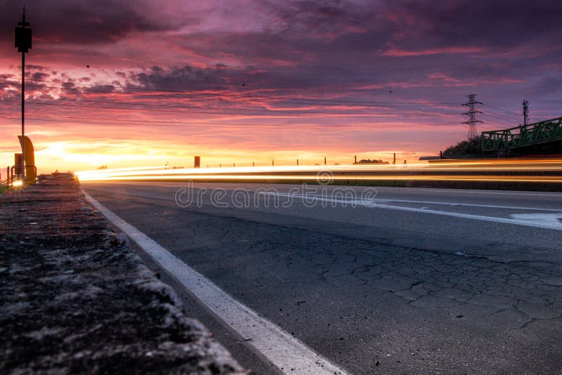 Sunset over road stock photo. Image of dawn, pylon, sundown - 137827534