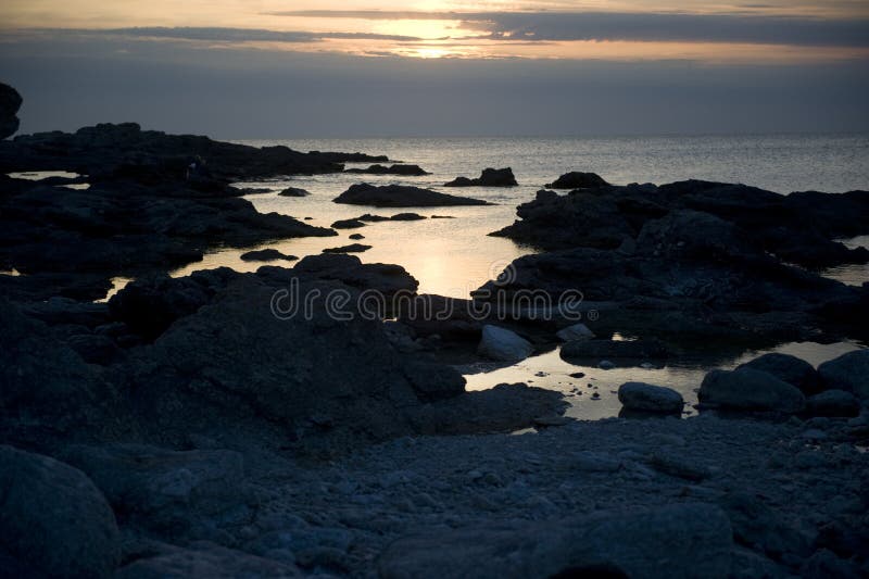 Sunset Over Rocky Shoreline Stock Photo - Image of coast, formations ...