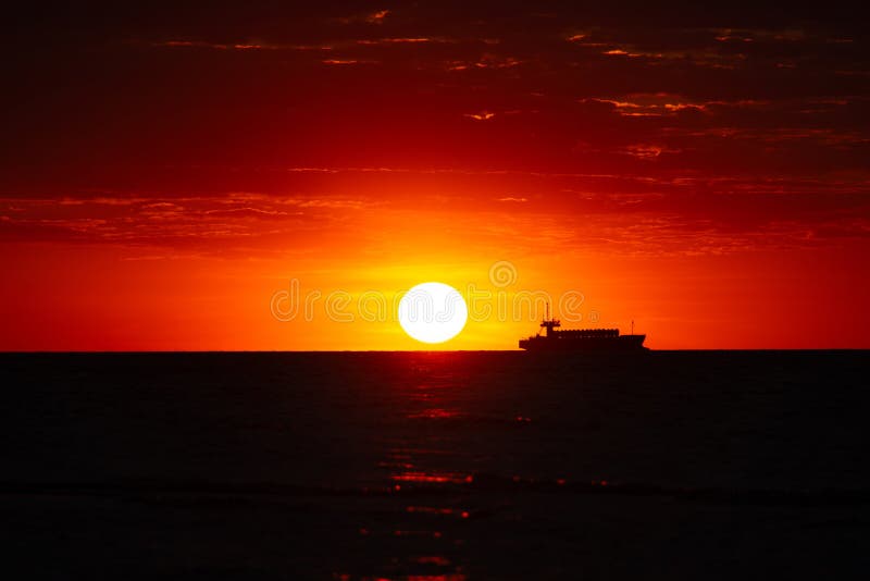 Sunset Over the Sea with a Ship on the Horizon Stock Photo - Image of ...