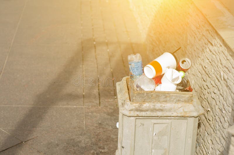 On Sunset, an Overflowing Trash Bin on Pavement Stock Photo - Image of ...