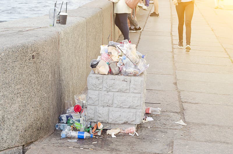 Sunset, an Overflowing Trash Bin and Scattered Garbage on the ... Sunset, an Overflowing Trash Bin and Scattered Garbage on the ...