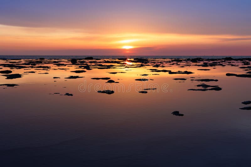 Sunset Reflected on the Sea As in a Mirror with Rocks Emerging on the ...