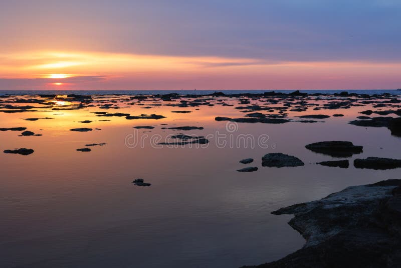 Sunset Reflected on the Sea As in a Mirror with Rocks Emerging on the ...
