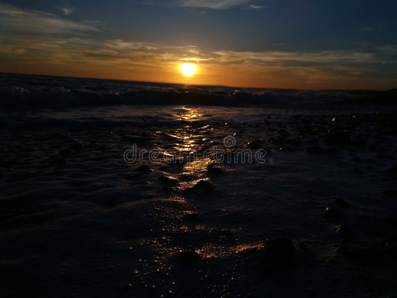 Sunset reflecting in waves stock photo. Image of england - 131759626