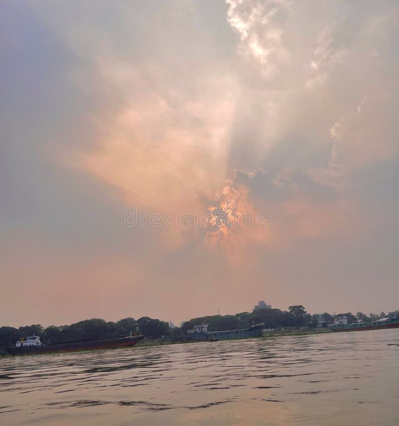 River Scene with Sunlight Breaking through Clouds at Sunset. Stock ...