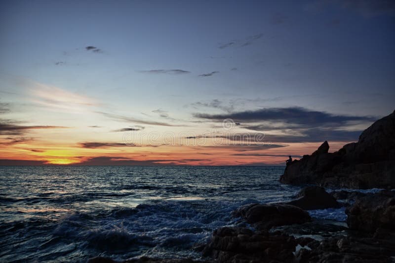 Sunset, Rocks and Fisherman on Sea Stock Image - Image of calm ...