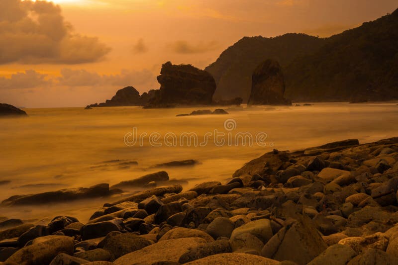 Sunset at the Rocky Beach in Papuma, Jember, East Java, Indonesia Stock ...