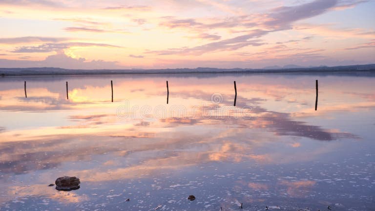Sunset on the Salt Lagoon with Reflections of Clouds and Silhouettes of ...