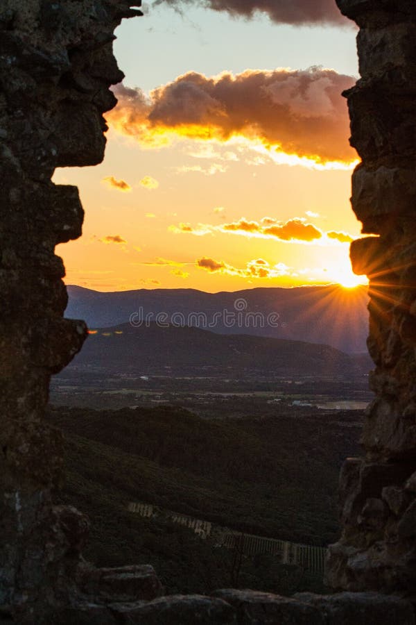 Sunset Scene with Illuminated, Floating Clouds Over a Green Landscape ...