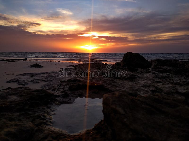 Sunset view on rocky beach stock photo. Image of wave - 210268984