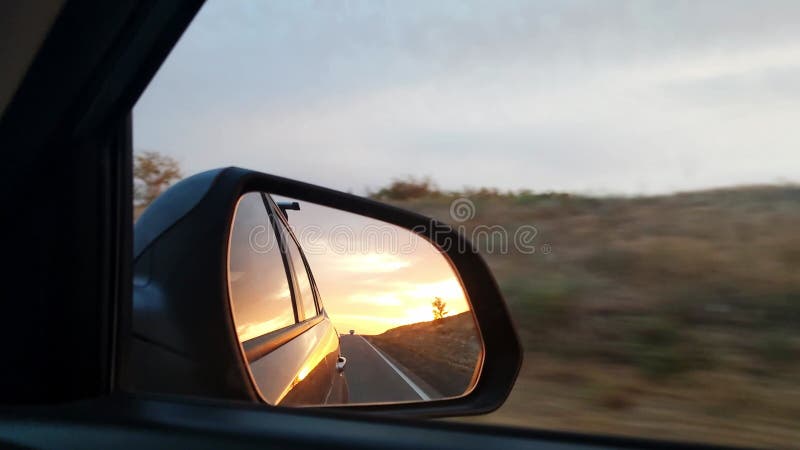Sunset View in the Side View Mirror of a Car Driving on the Road in the ...