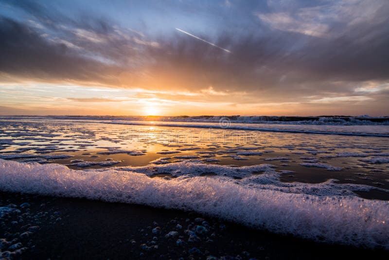 Sunset and Water Reflection on Beach Stock Photo - Image of clouds ...