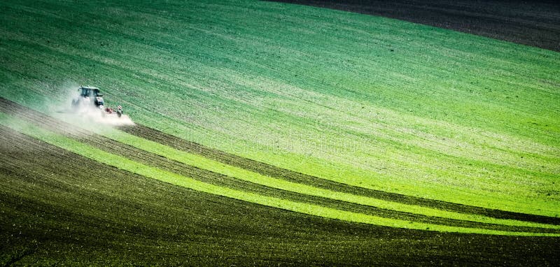 Sunshine View of Big Tractor Plowing the Ground of Green Field Stock ...