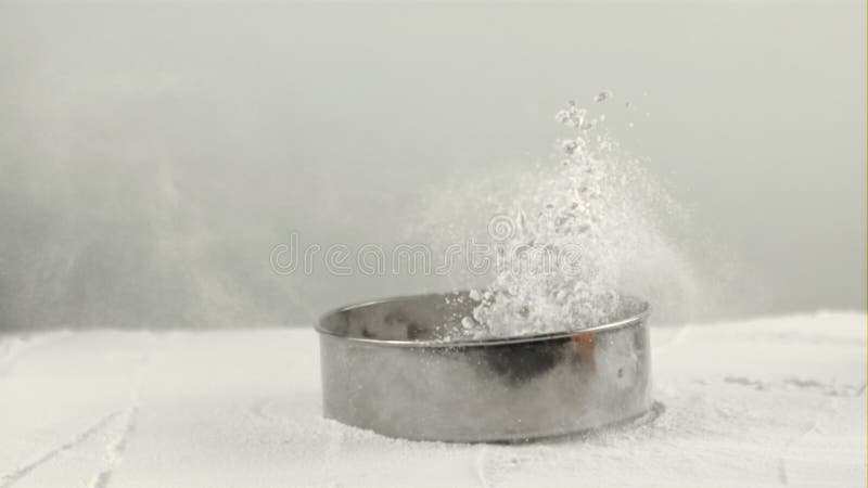 A Sieve of Flour Falls on the Kitchen Table. Filmed on a High-speed ...