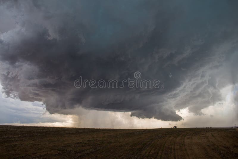 A Wall Cloud Gathers Under the Base of a Supercell Storm Over a Field ...