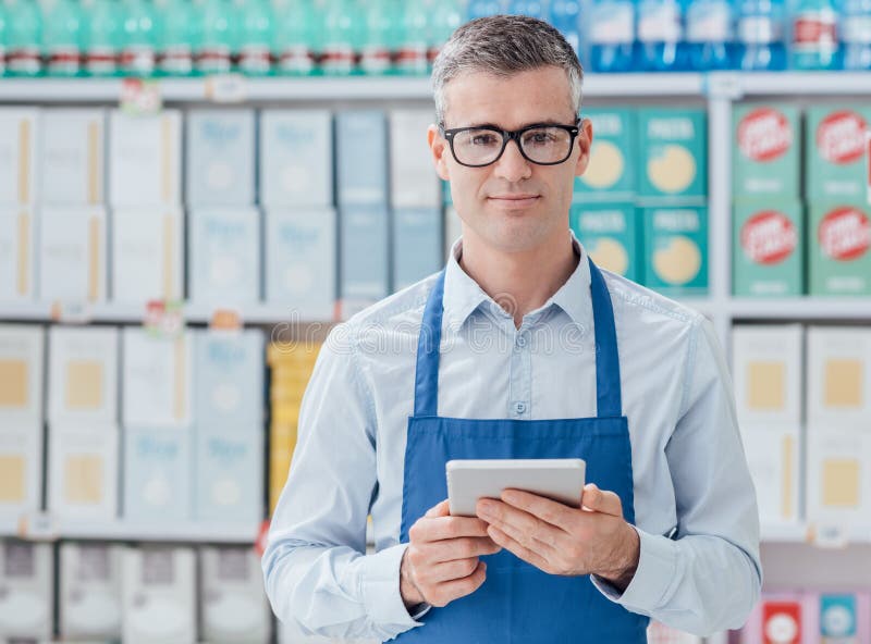 Supermarket Clerk Using a Tablet Stock Image - Image of retailer, happy ...