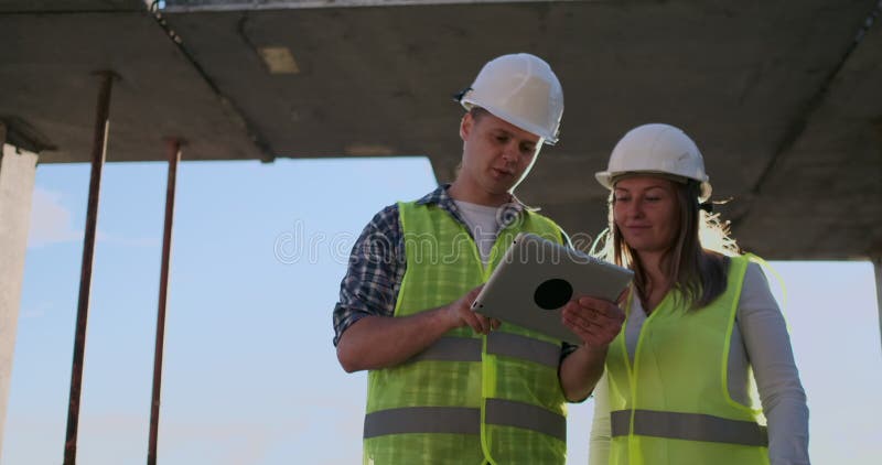 Supervisor of a Building Under Construction Man Discussing with ...
