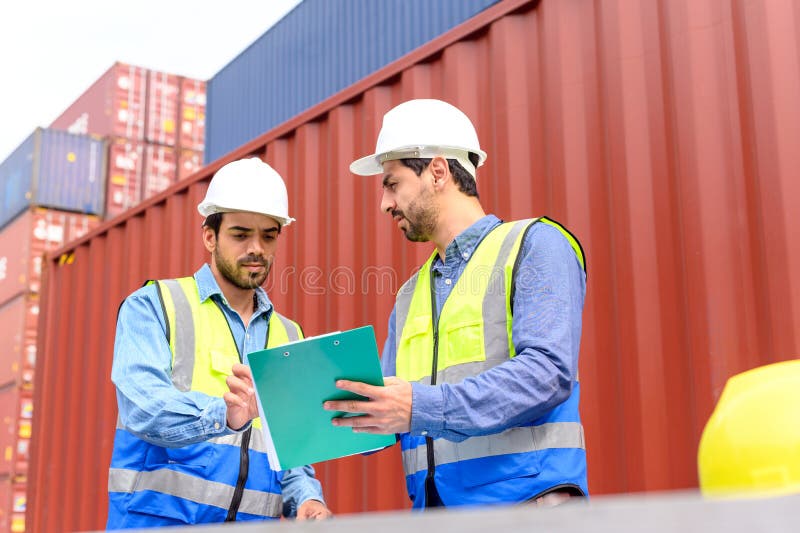 Supervisor and Colleagues in White Hard Hats and Safety Vests Stand in ...