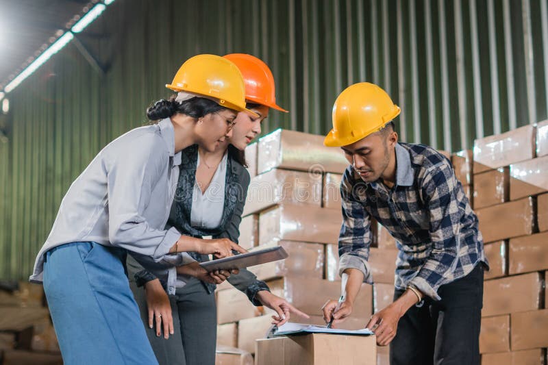 Supervisor Corrects the Work of Two Factory Employees during a Visit ...