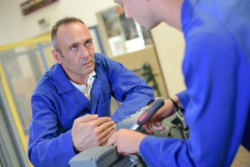 Supervisor Talking To Electronics Apprentice Using Multimeter Stock ...
