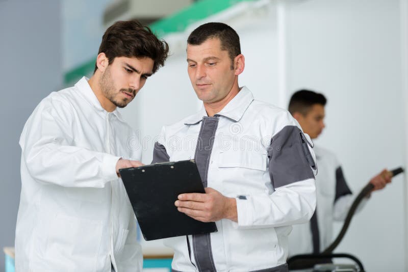 Supervisor Talking To Apprentice Using Paint Roller Stock Image - Image ...