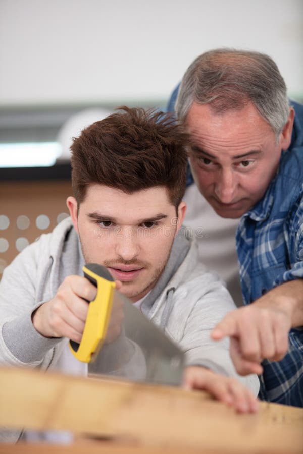 Supervisor Watching Apprentice Use Handsaw Stock Image - Image of ...