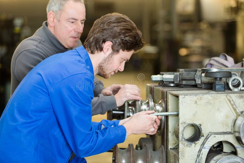 Supervisor Watching Trainee Work on Machine Stock Photo - Image of ...