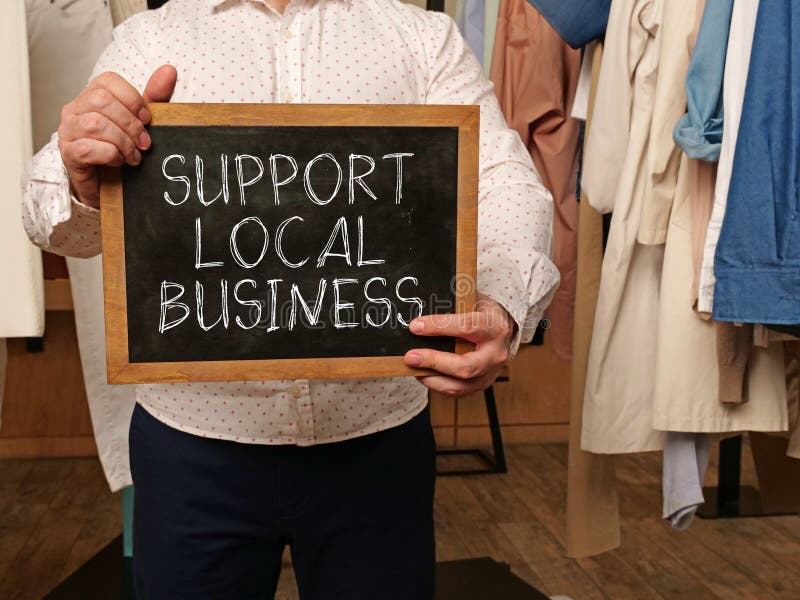 Support Local Business is Shown Using the Text on a Board Held by a ...