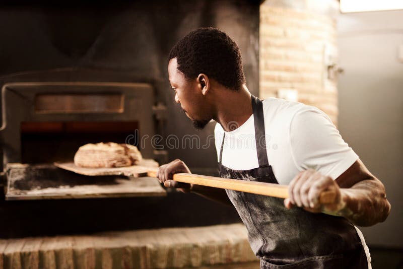 Support Your Local Baker. a Male Baker Removing Freshly Baked Bread ...