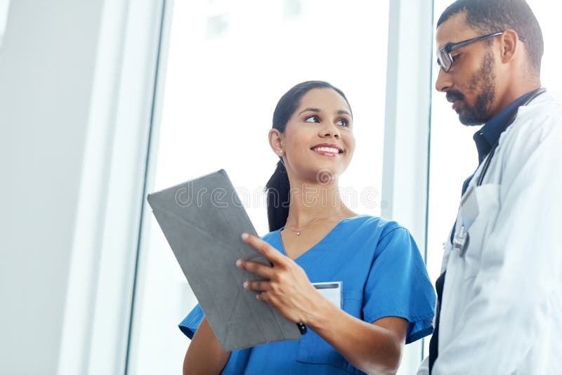 Supporting Their Diagnosis with Digital Tech. Two Young Doctors Using a ...