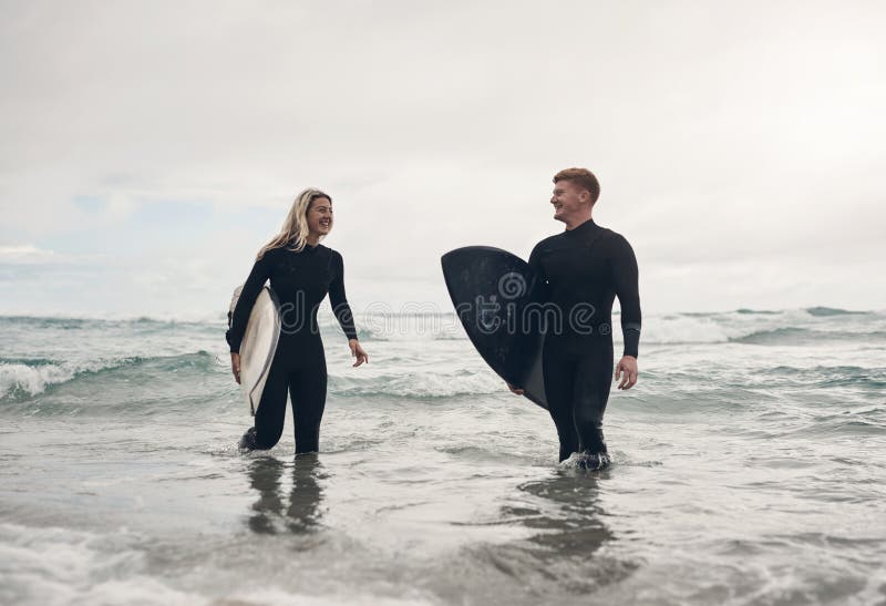 We Surf because Its Fun. a Young Couple Out at the Beach with Their ...